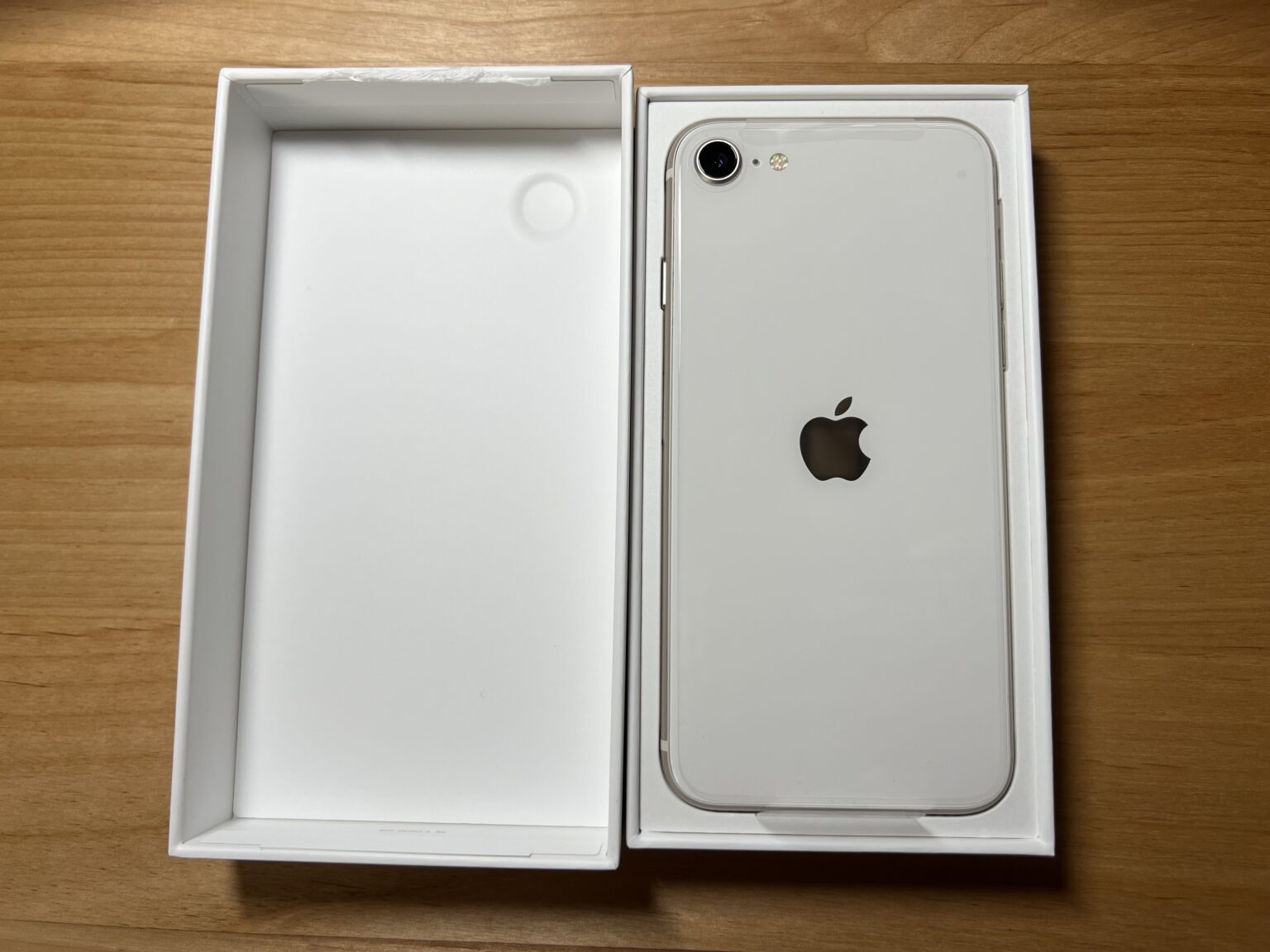 iPhone SE3（第3世代）の本体には表裏に透明フィルムが貼られており、本体下に付属品が収納されています。