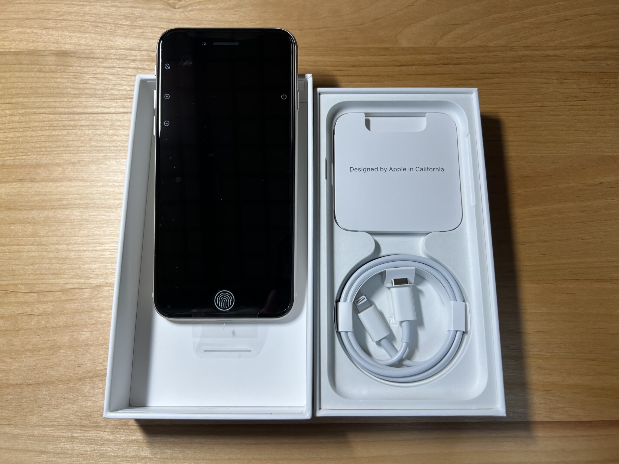 iPhone SE3（第3世代）の本体には表裏に透明フィルムが貼られており、本体下に付属品が収納されています。